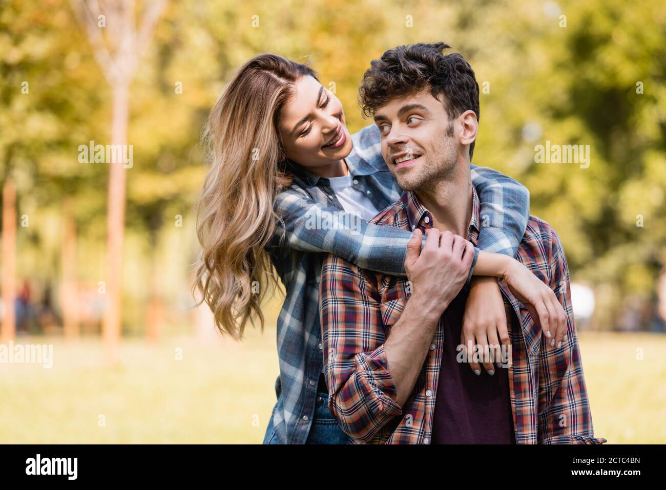 woman hugging man in checkered shirt in park Stock Photo - Alamy