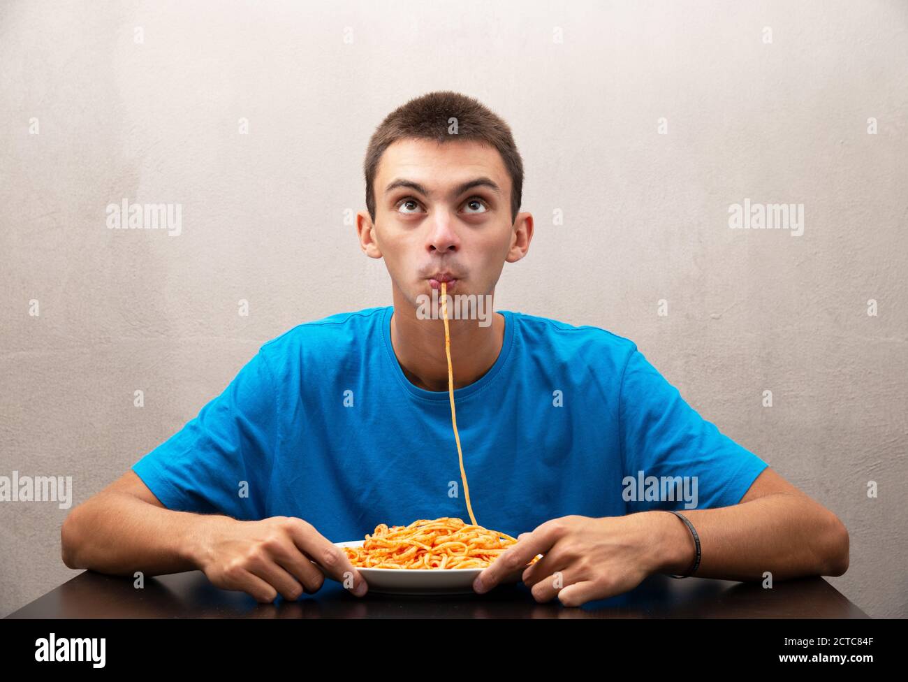 Man eating spaghetti with tomato sauce hi-res stock photography and ...
