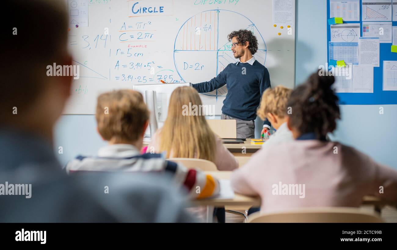 Caring Teacher Explains Lesson to a Classroom Full of Bright Diverse ...
