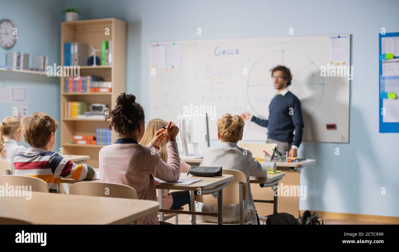 Caring Teacher Explains Lesson to a Classroom Full of Bright Diverse ...