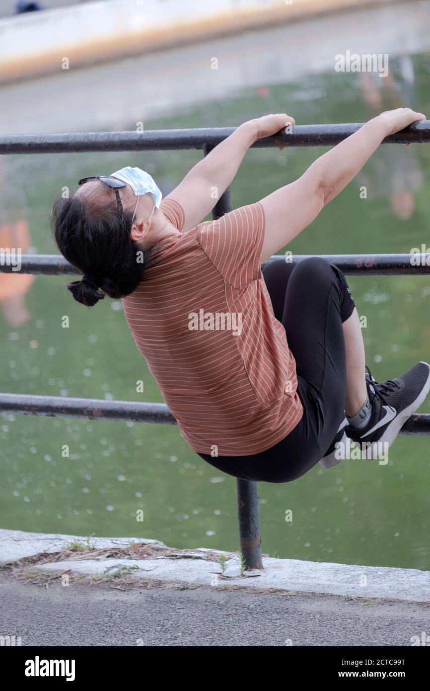 A middle aged Asian American woman stretches before her morning ...