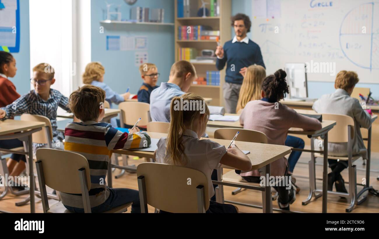 Caring Teacher Explains Lesson to a Classroom Full of Bright Diverse ...