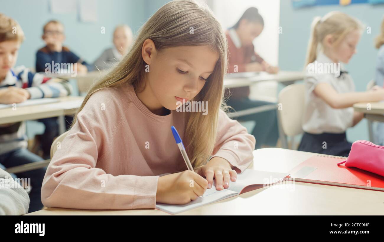 In Elementary School Classroom Caucasian Girl Writes in Exercise ...