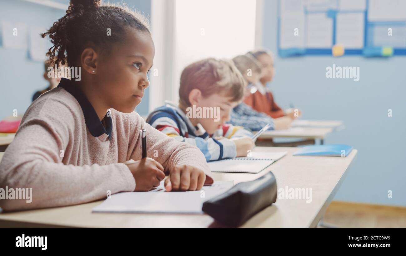 In Elementary School Classroom Brilliant Black Girl Writes in Exercise ...
