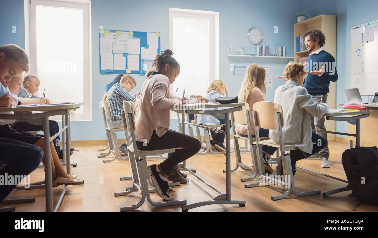 Enthusiastic Teacher Explains Lesson to a Classroom Full of Diverse ...