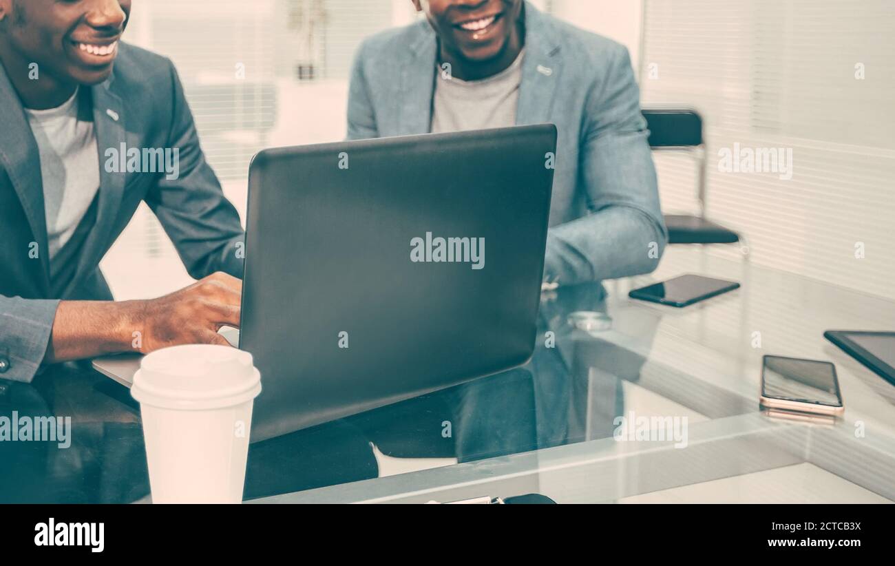 smiling colleagues looking at work on a laptop in the office Stock ...