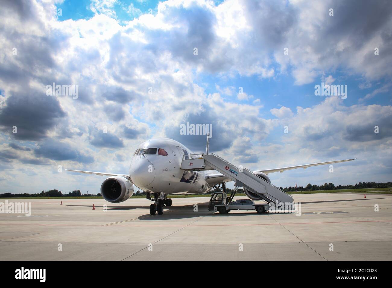Boeing 787-8 Dreamliner with passenger boarding stairs vehicle against ...