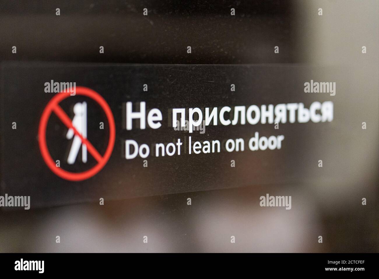 The sign: Do not lean on door (translation). A human palm leaned ...