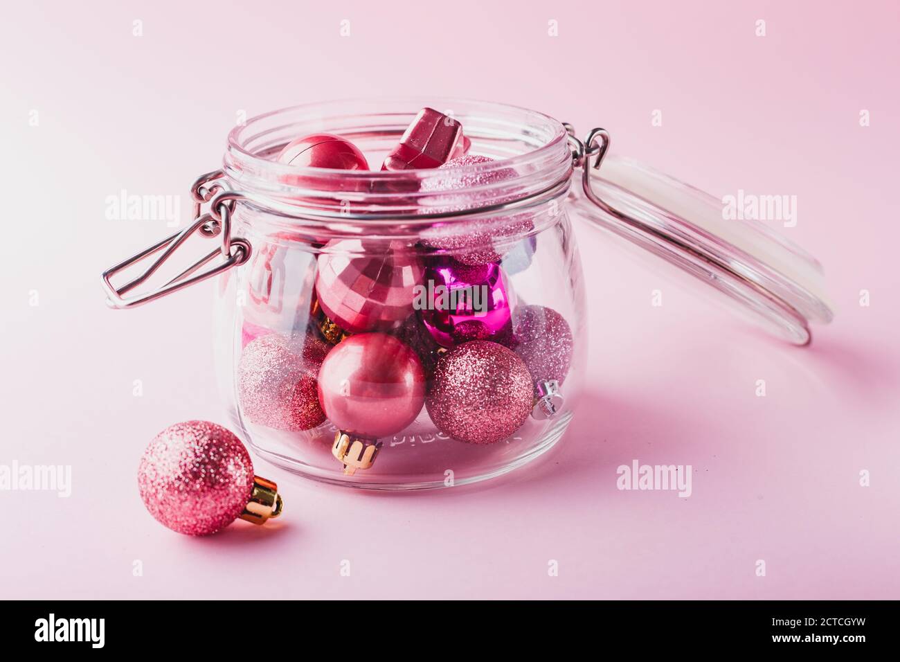Small pink Christmas balls in glass jar on pink background Stock Photo ...