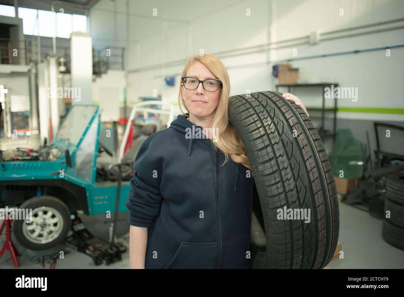 Female repairman fixing a car at the mechanic workshop Stock Photo - Alamy