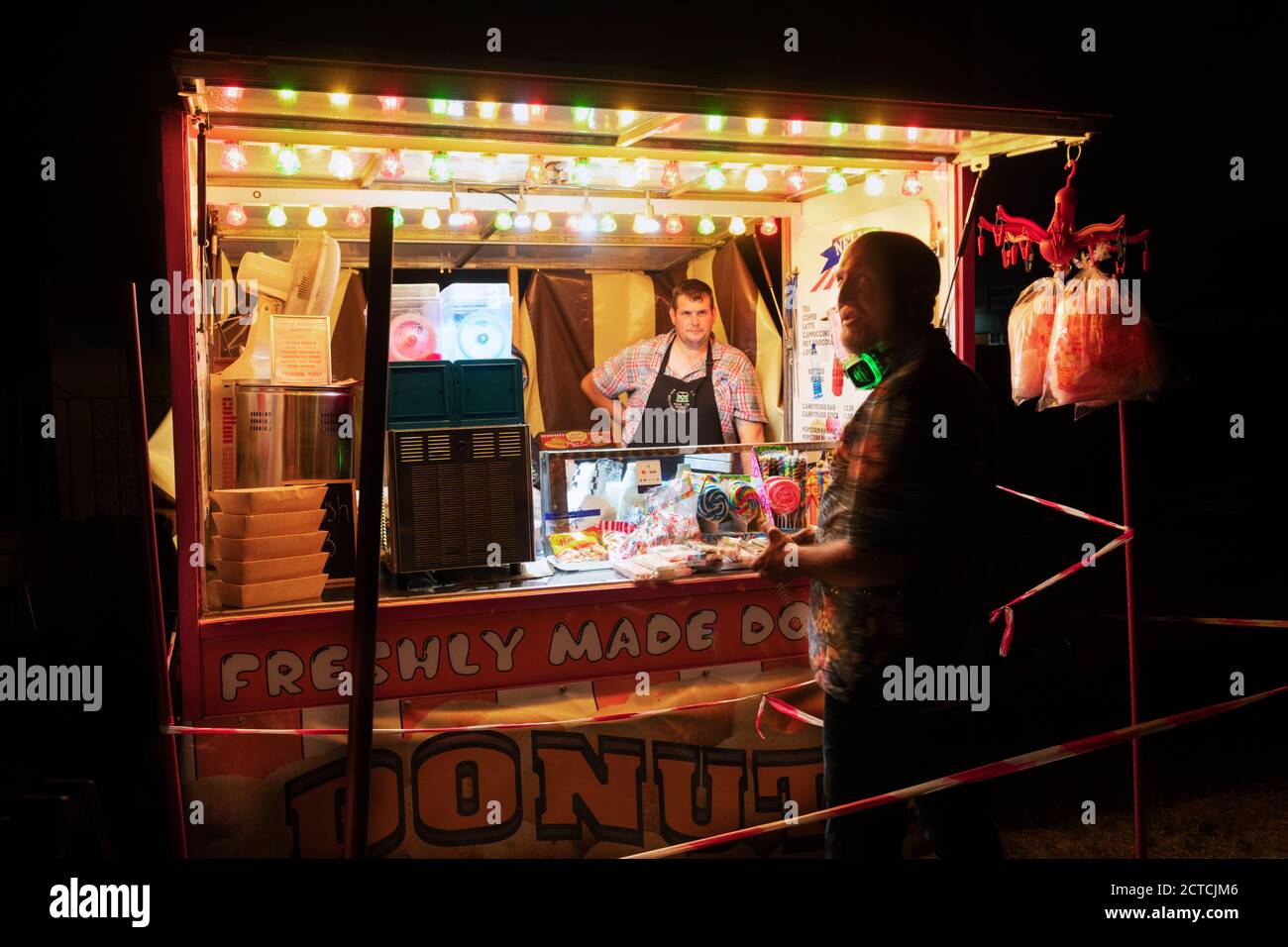 Fairground doughnut booth at night Stock Photo - Alamy