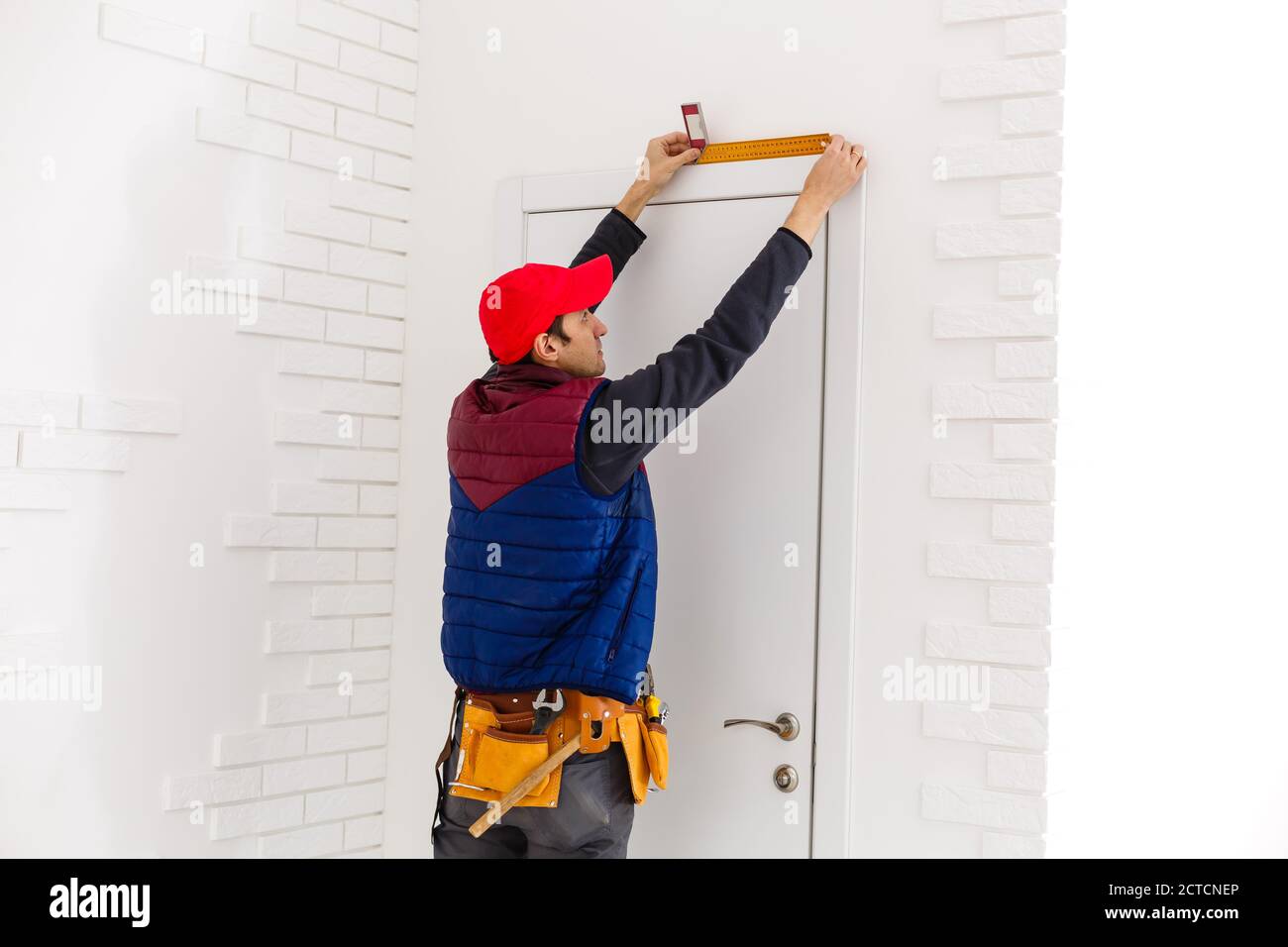 handsome young man installing a door in a new house construction site ...