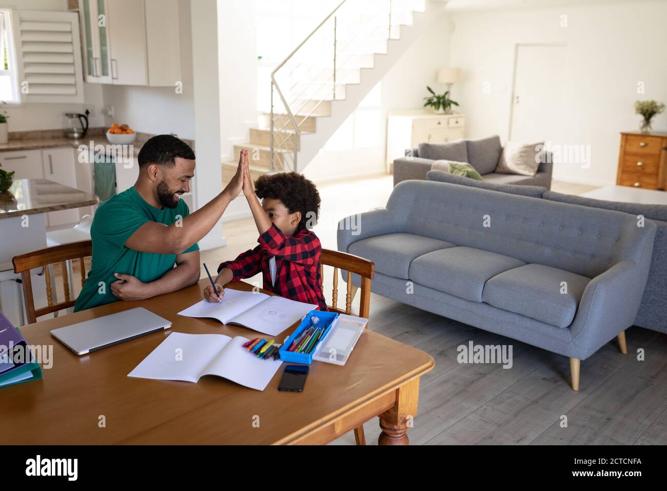 Father and son high fiving each other at home Stock Photo - Alamy