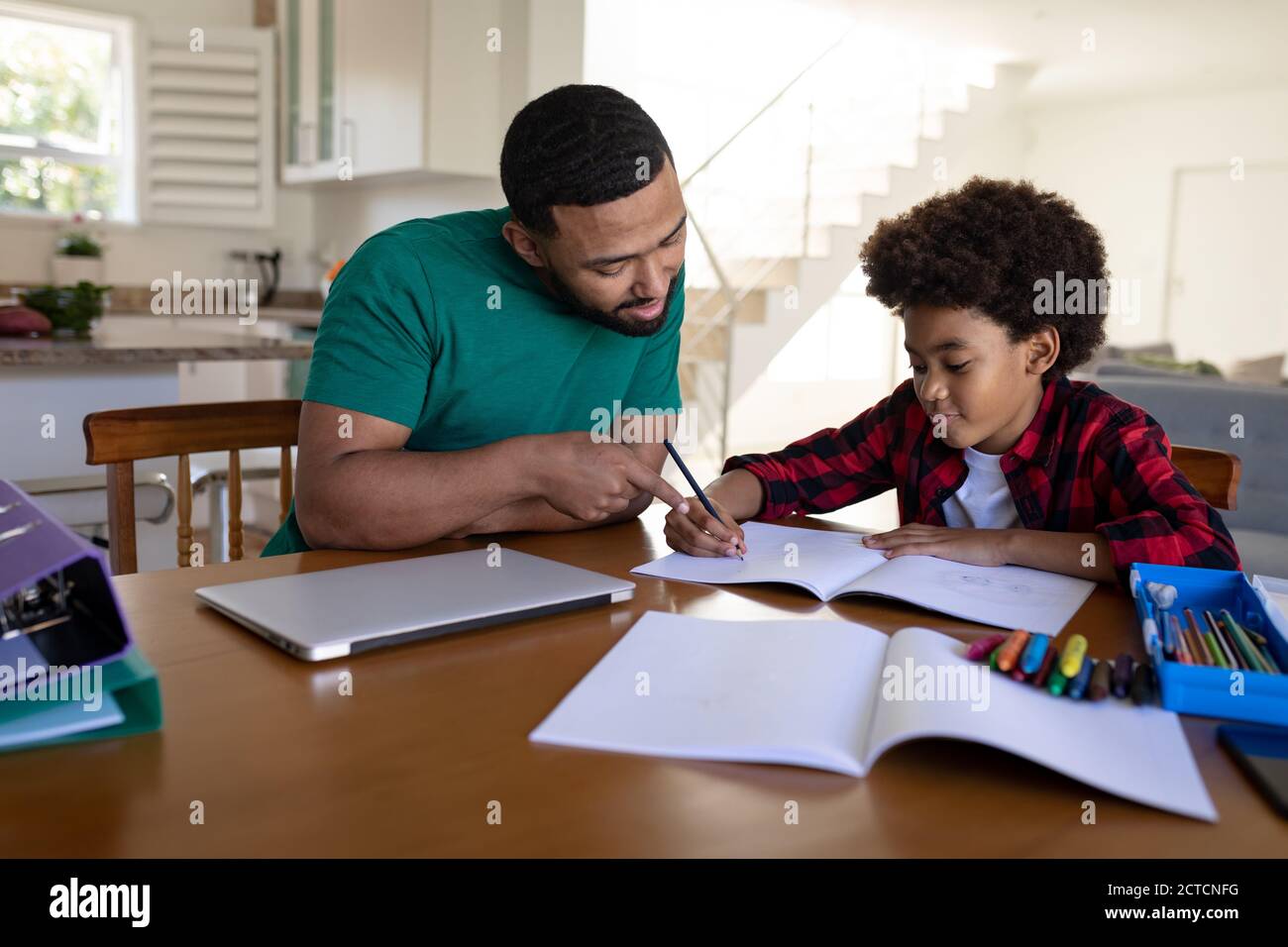 Father helping son with homework at home Stock Photo - Alamy