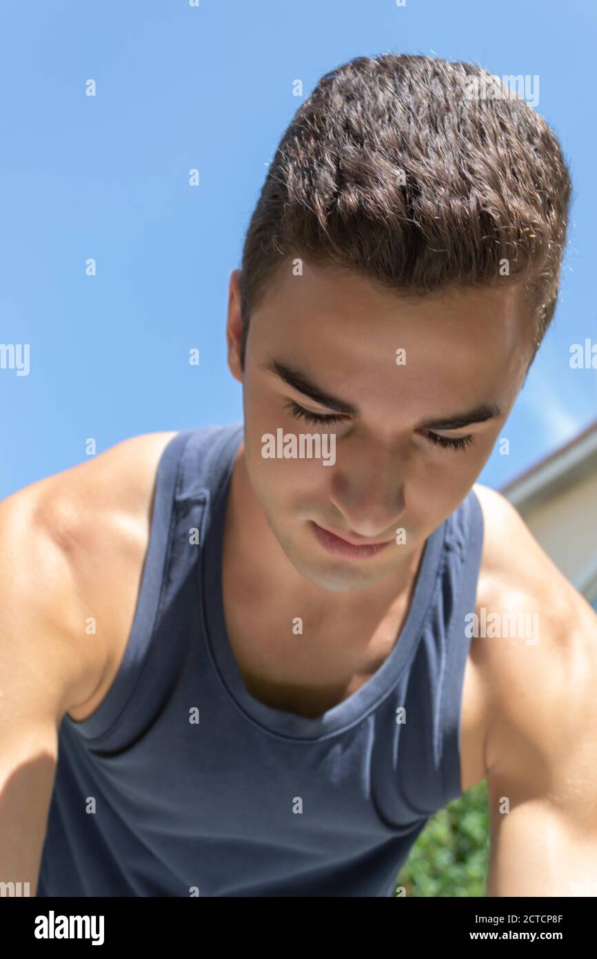 detail of a young man doing a cross-training session in the garden of ...