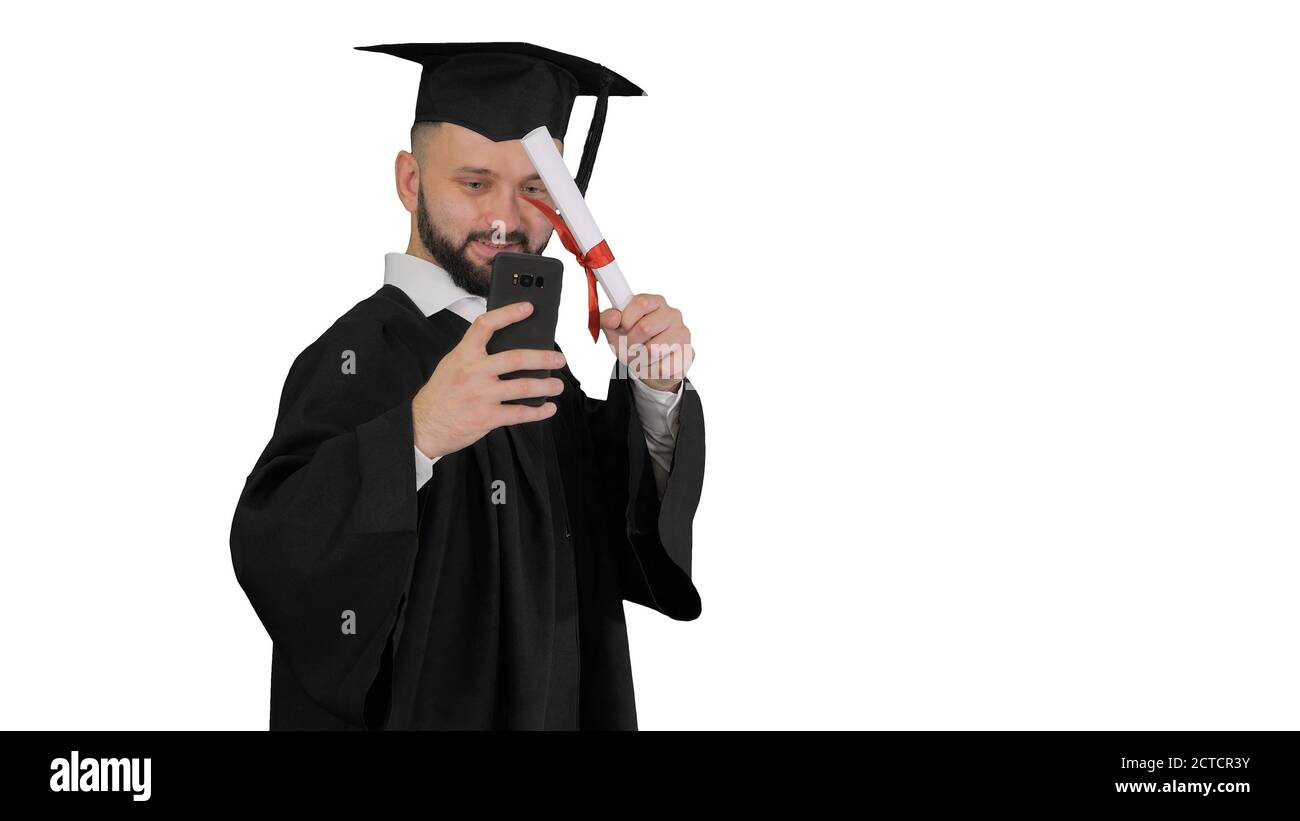 Man wearing the graduation robe walking and taking selfie with d Stock ...