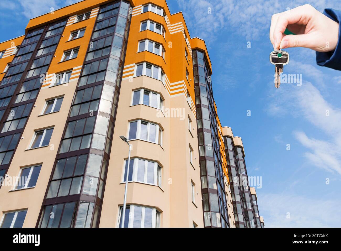Hand with keys in the background apartment building Stock Photo - Alamy