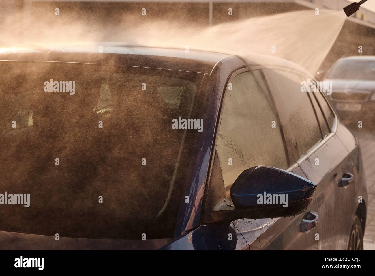 Manual car washing using a high pressure water. Side view of cleaning ...