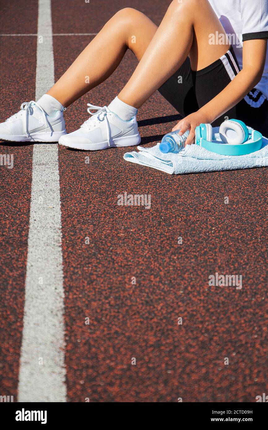 a female runner rests after a hard run on a sports field. Workout Stock ...