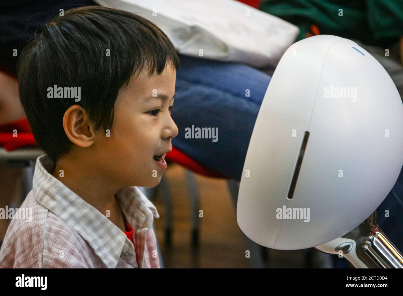 A boy happily talking to a robot, eager to receive some response Stock ...