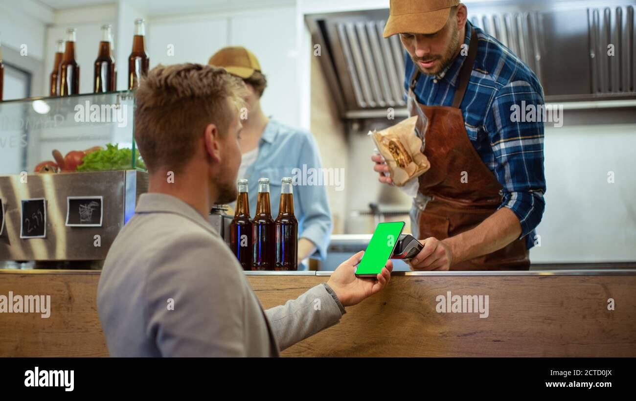 Food Truck Employee Hands Out a Freshly Made Burger to a Happy Young ...