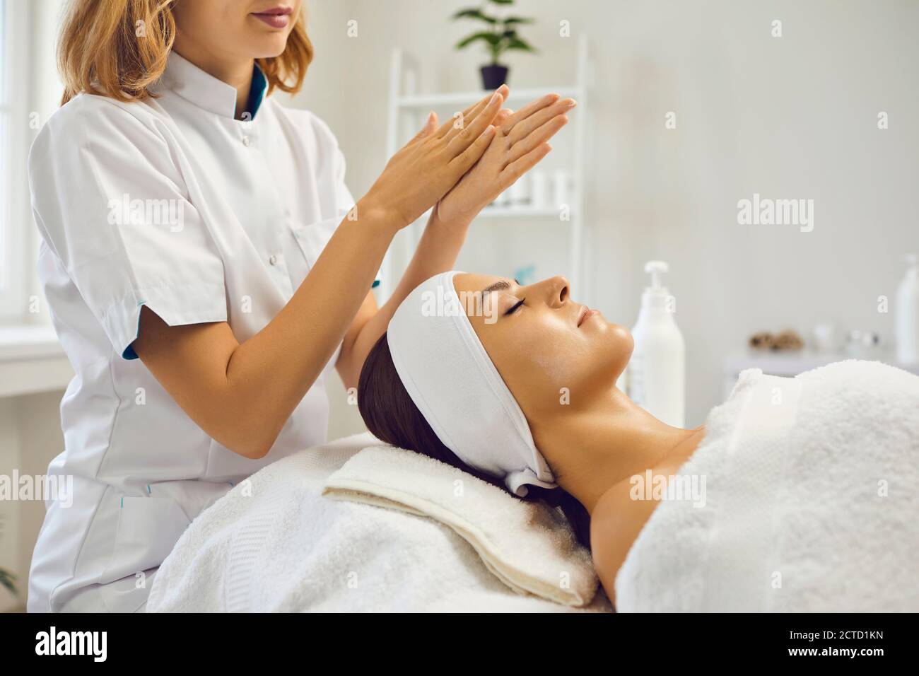 Dermatologist or therapist spreading moisturizing cream on hands to ...