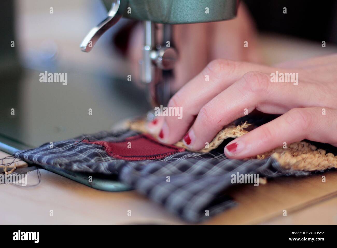 Sewing with machine. Detail of tailor hand working with fabric Stock ...