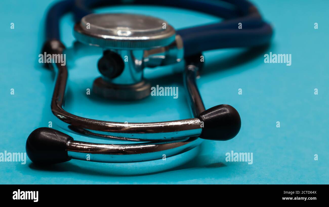 Old shabby stethoscope on a blue background Stock Photo - Alamy