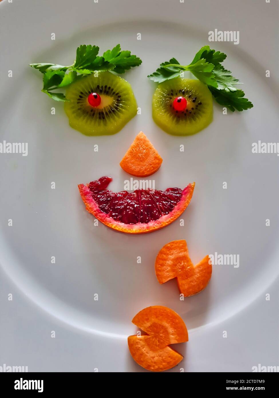 Vegetable face on a white plate Stock Photo - Alamy