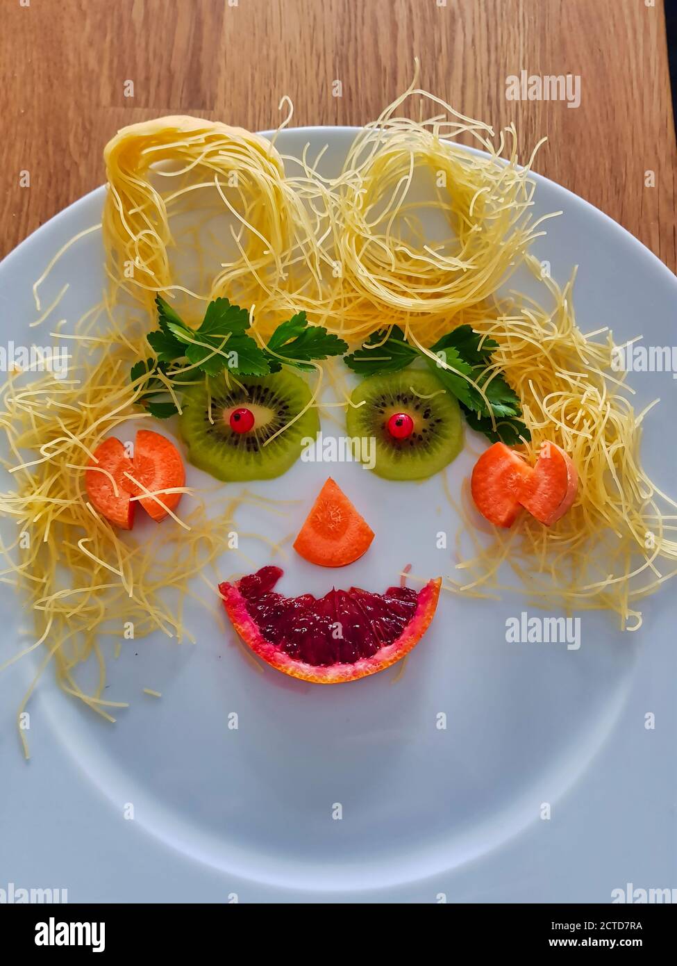 Vegetable face on a white plate Stock Photo - Alamy