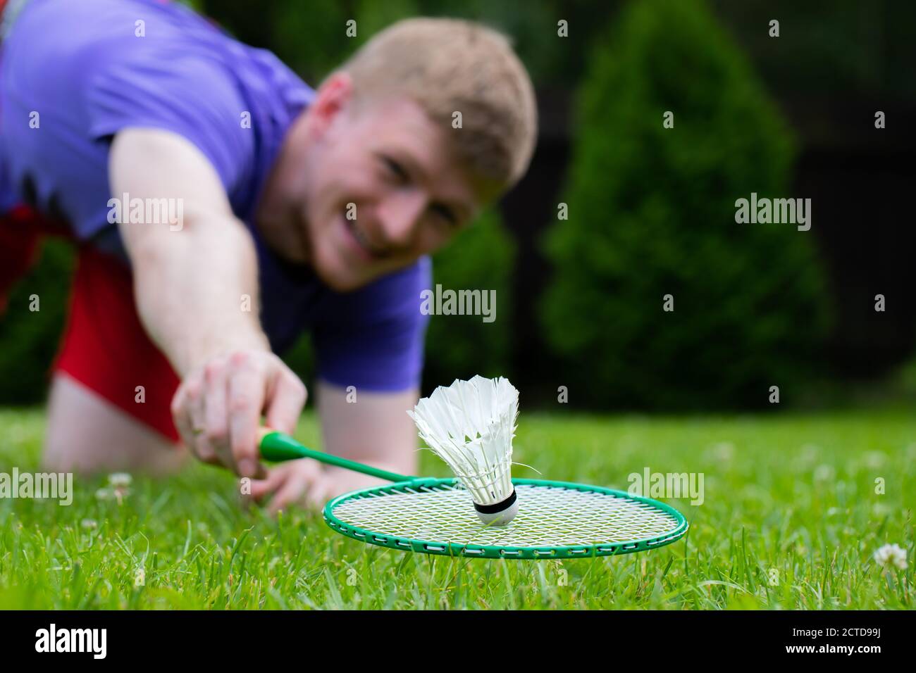 Close up badminton player with racket in action. Young man playing ...