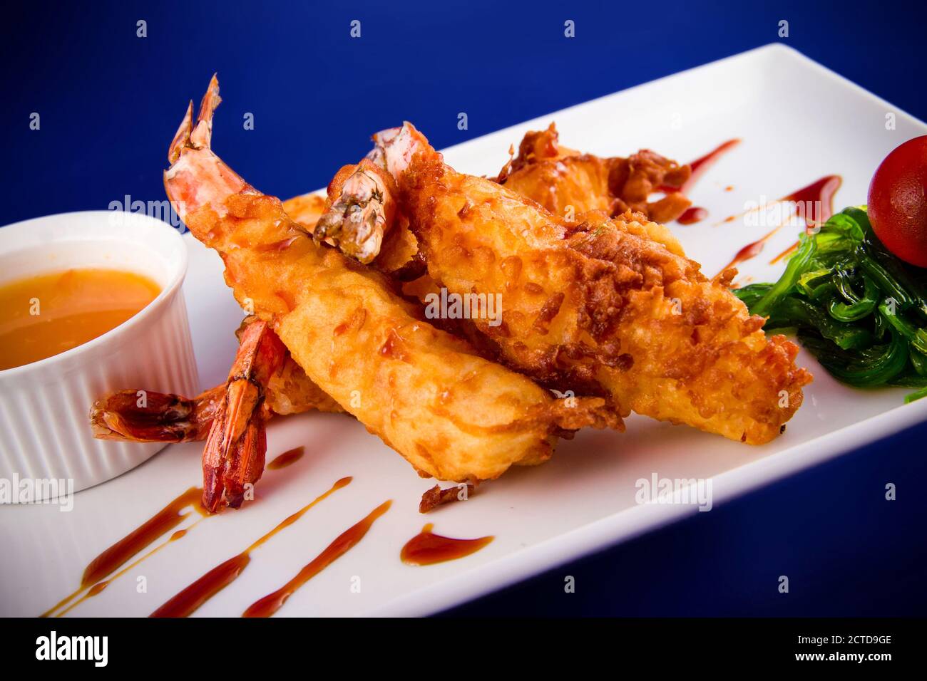 Deep-fried tiger prawns in batter served with sweet and sour sauce ...