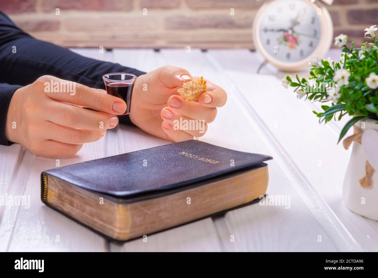Young woman praying and Taking communion - the wine and the bread ...