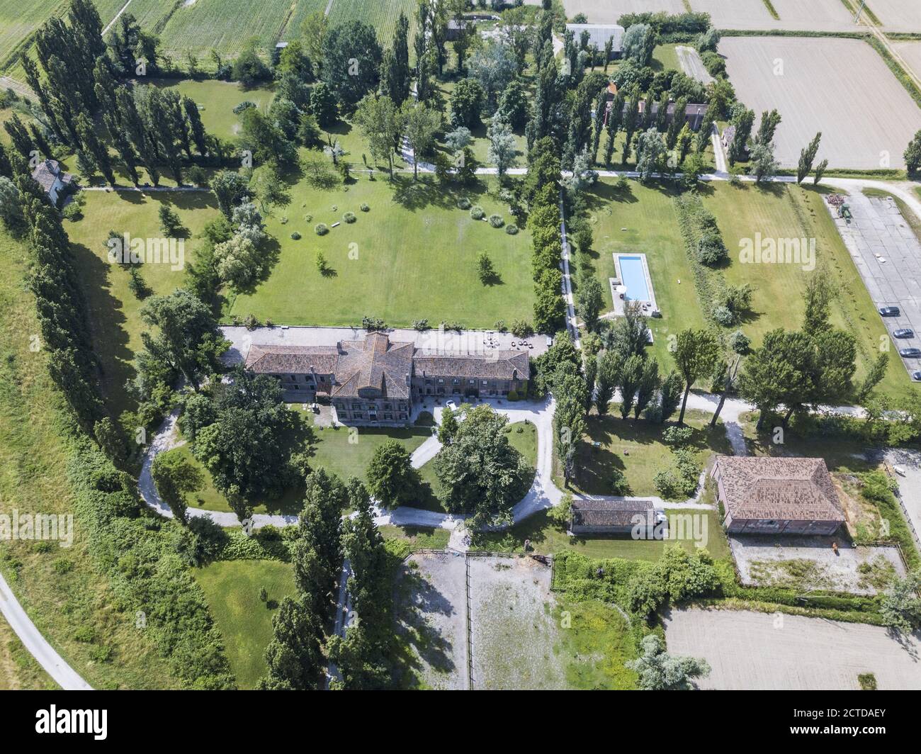 An aerial shot of a residential plot with a large house surrounded by ...