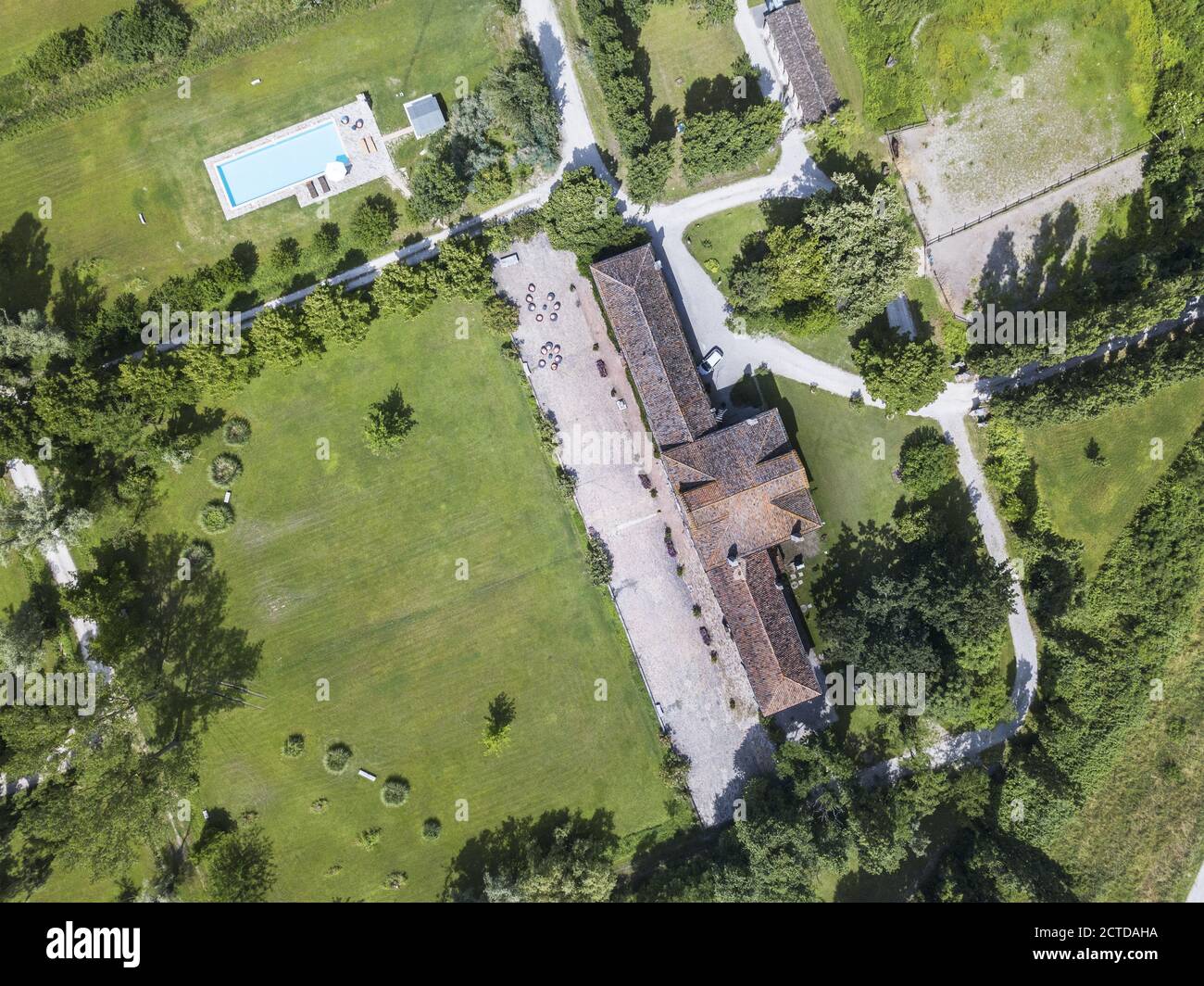 An aerial top view of a residential plot with house, trees, and a pool ...