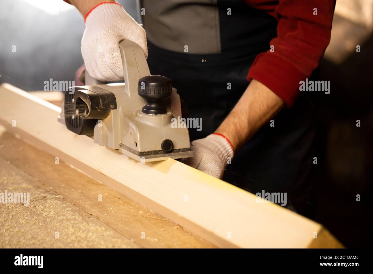 electric planer chamfering wooden workpiece on workbench Carpentry work ...