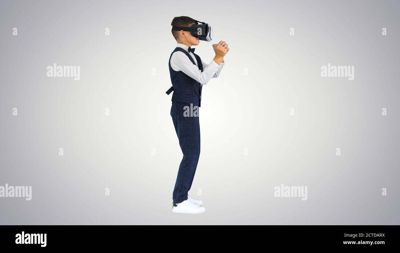Boy in formal wear playing the sword game in virtual reality gog Stock ...
