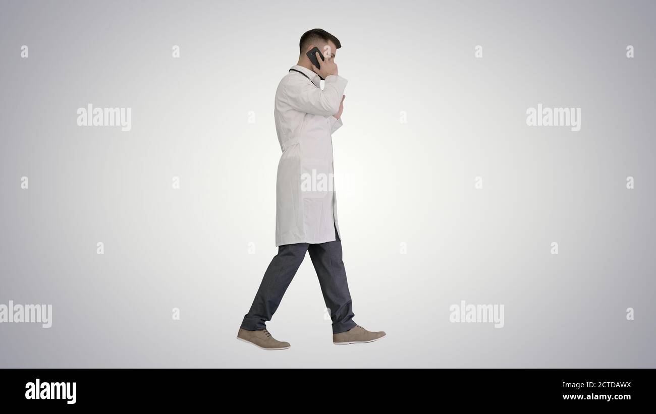 Medical doctor calling by phone walking on gradient background Stock ...