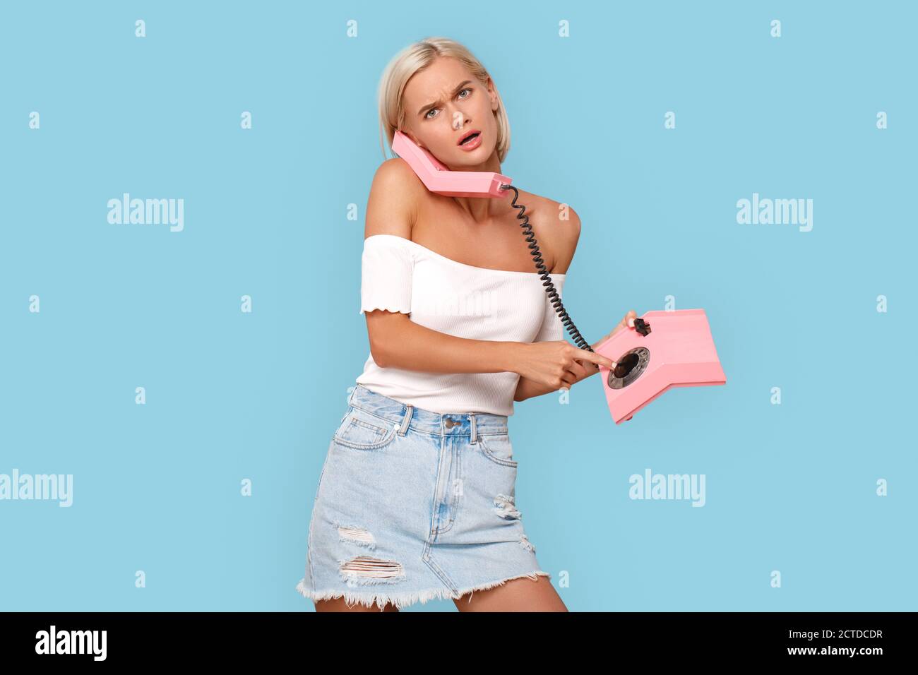 Young adult girl using rotary phone, making call Stock Photo - Alamy