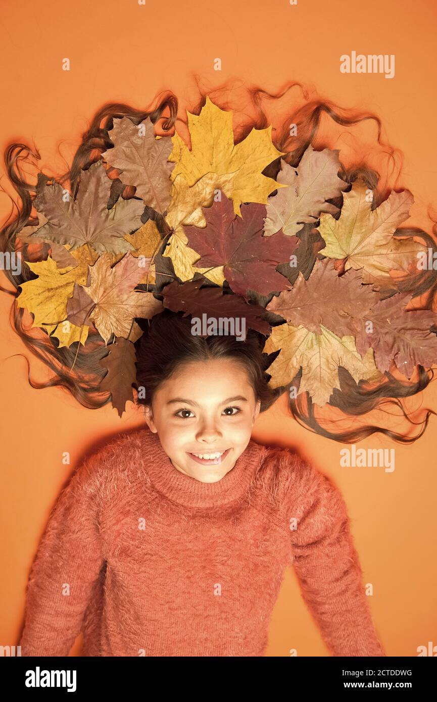 Autumn leaves are falling down. Happy girl wear colorful leaves in long ...
