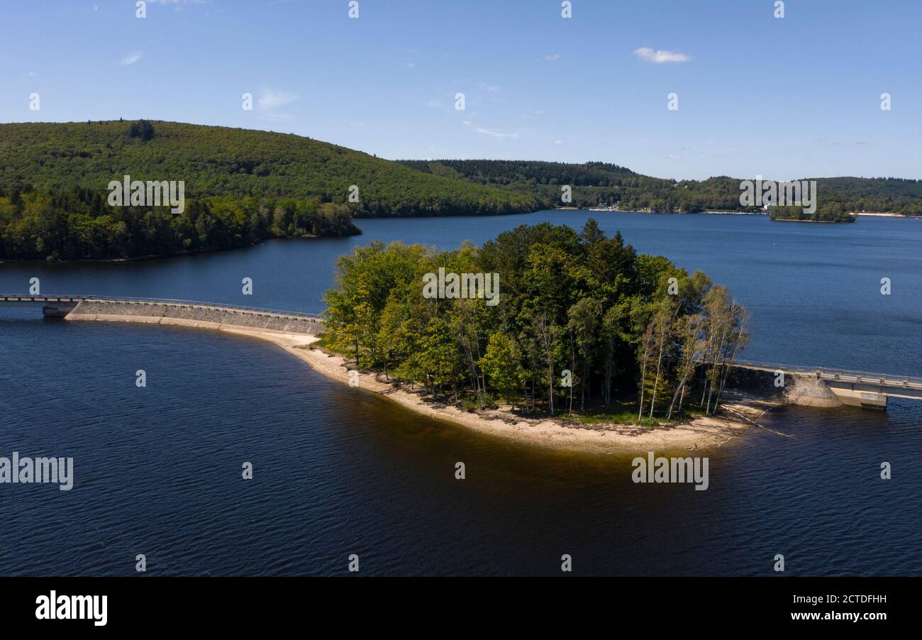 Aerial photo of a tiny green forest covered island crossed by a road in ...