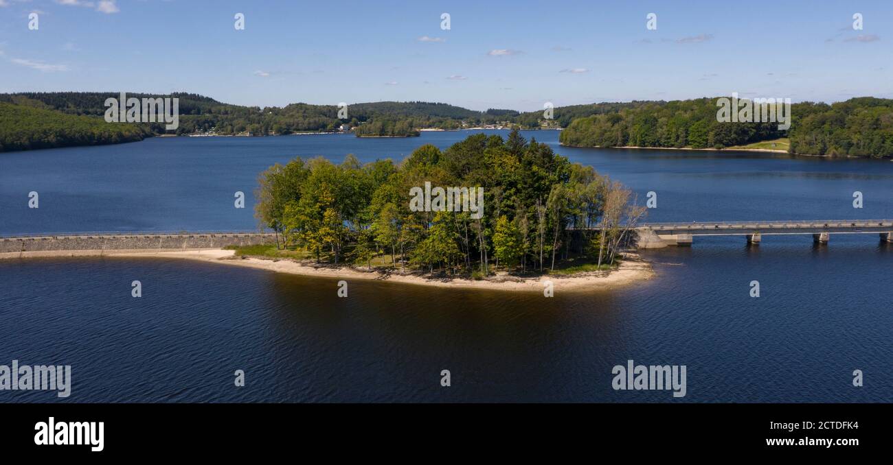 The tiny green forest covered island crossed by a road in the middle of ...