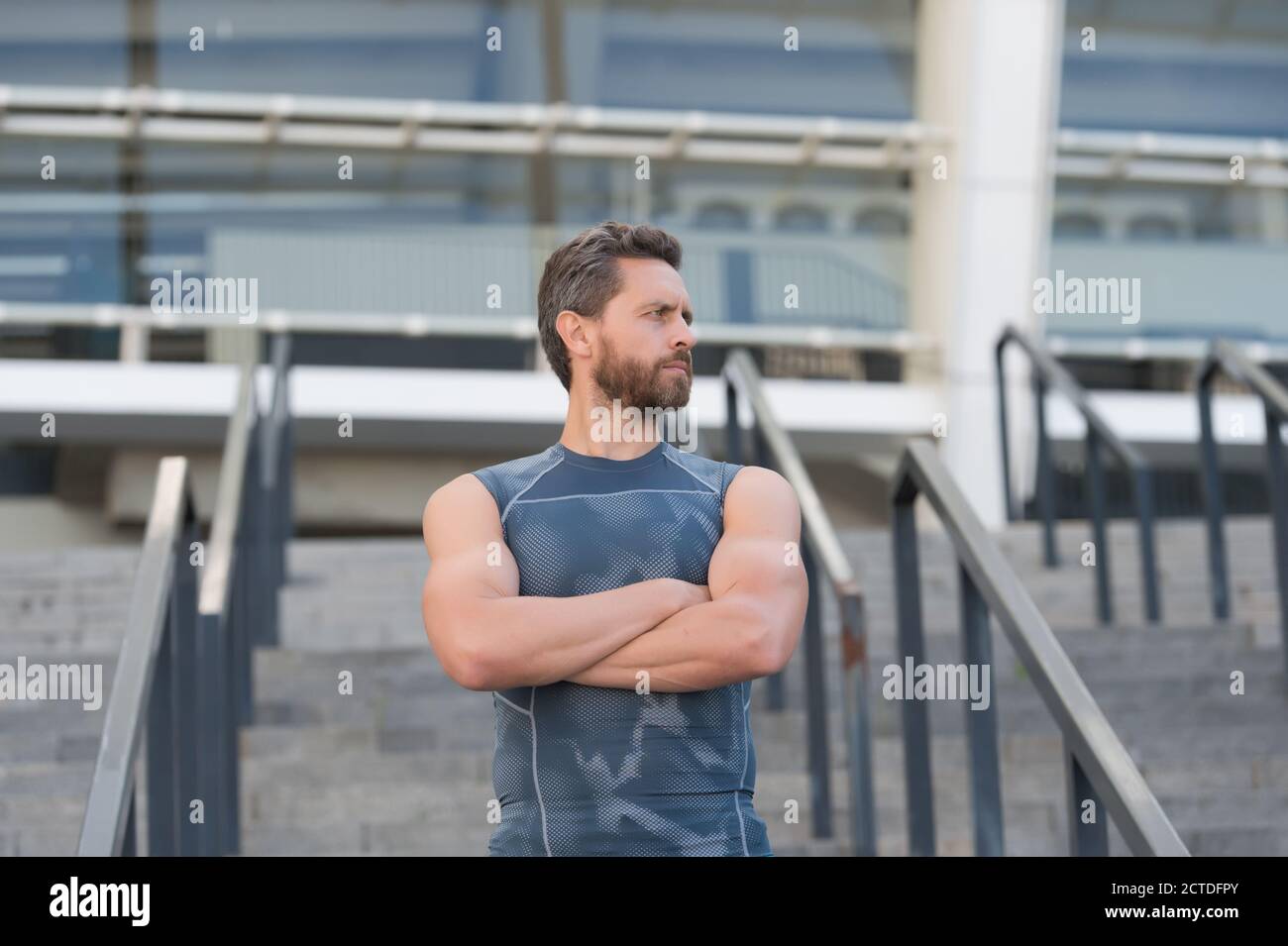 Man muscular fitness coach waiting on stairs stadium entrance ...
