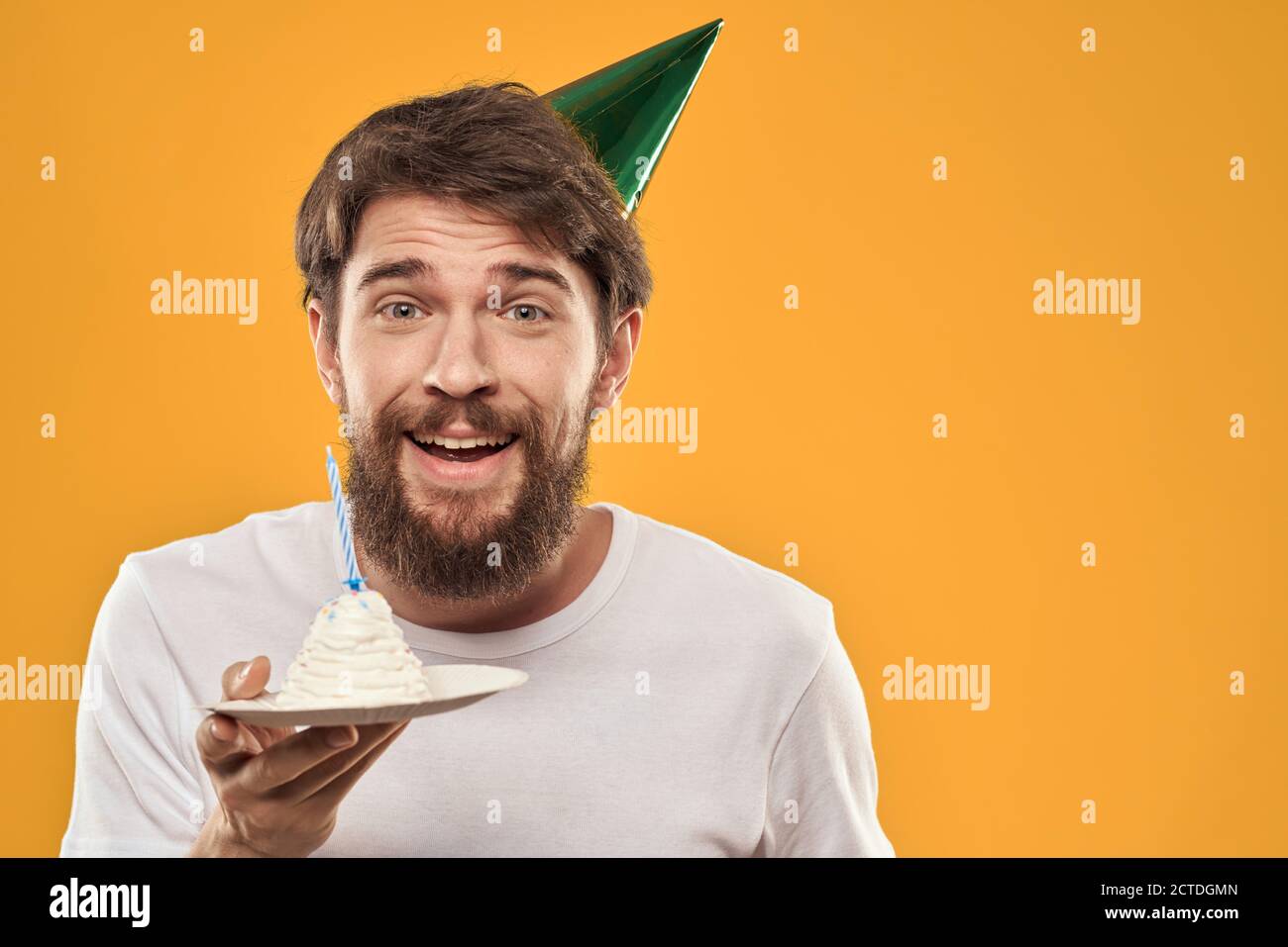 A bearded man with a cake and in a cap celebrating his birthday Stock ...