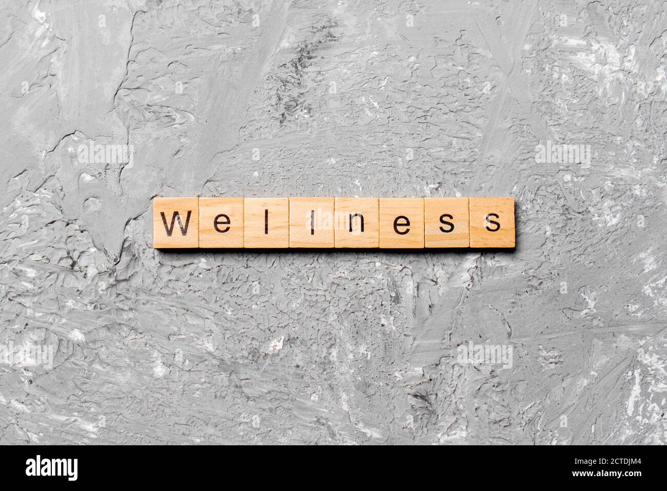 Wellness word written on wood block. Wellness text on cement table for ...