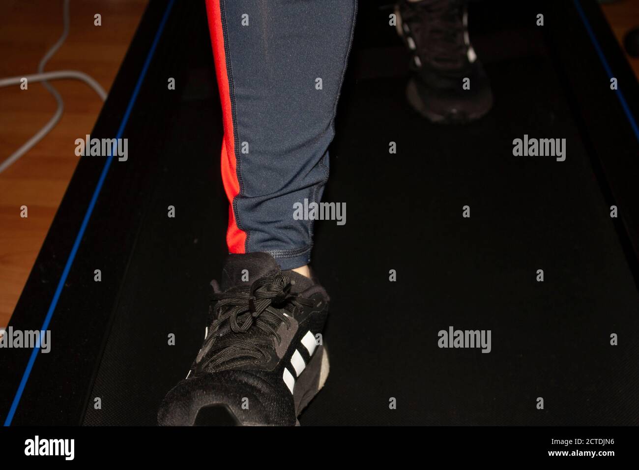 Right foot in front and left back taking steps on the treadmill to ...