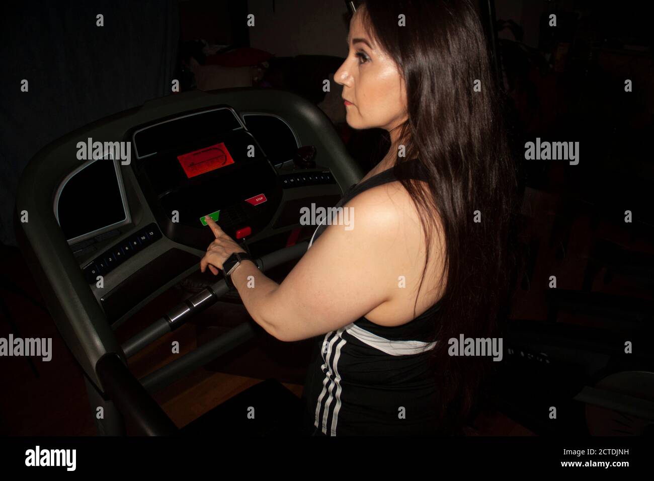 Mexican woman starting physical training routine on treadmill in Mexico ...