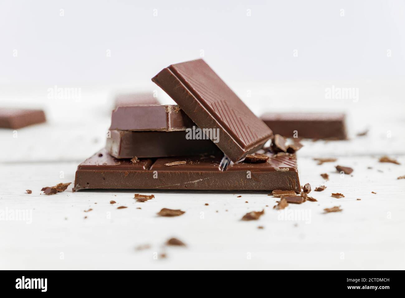 Chocolate bars on wooden table. Broken pieces of dark chocolate. Food ...