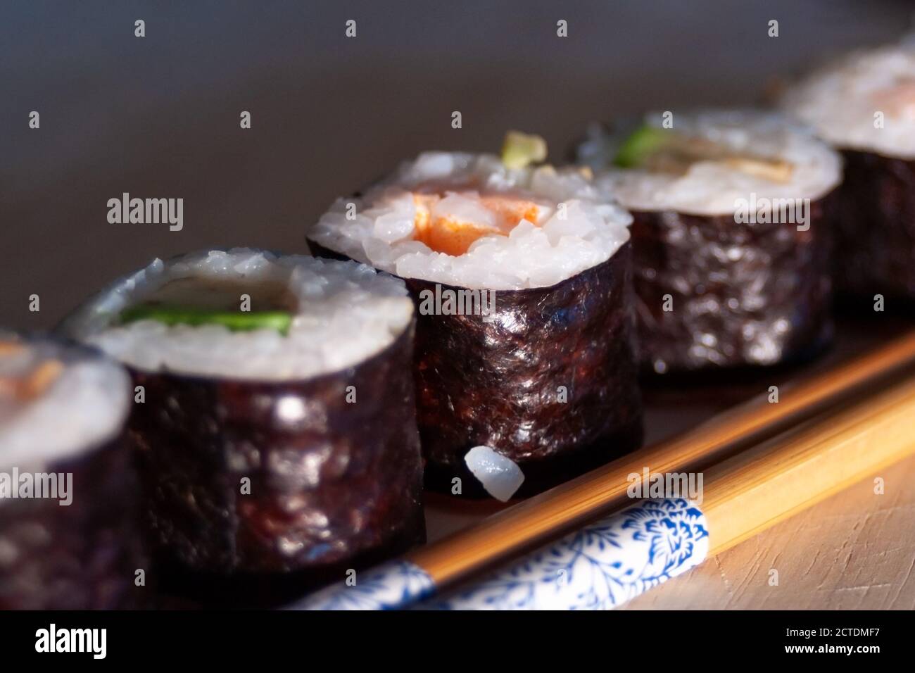 sushi in a row with chopsticks on a wooden base Stock Photo - Alamy