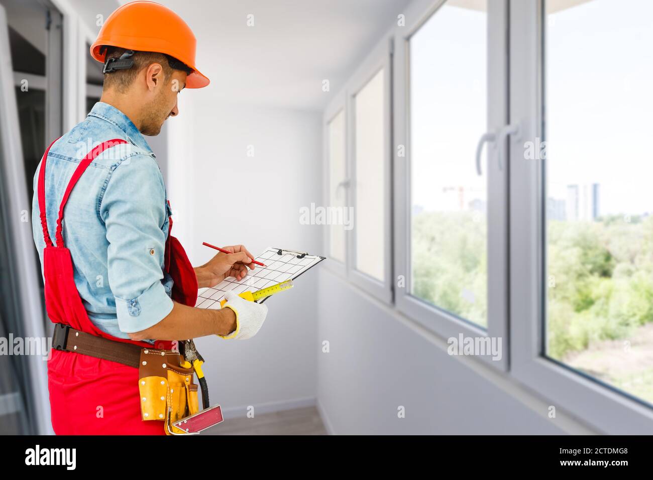 Worker with a diy tool belt over construction background Stock Photo ...